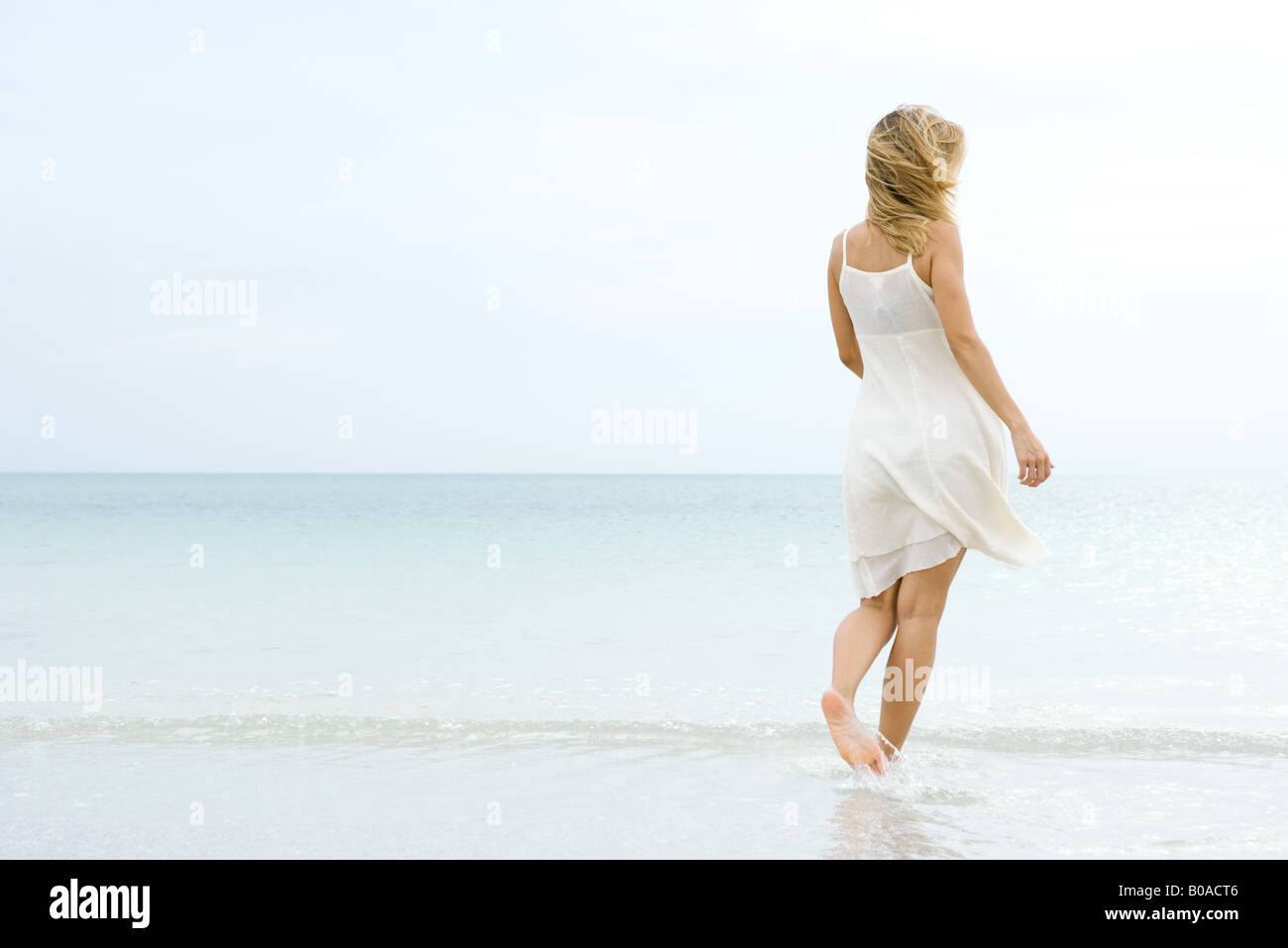 Woman walking at the beach, rear view Stock Photo - Alamy