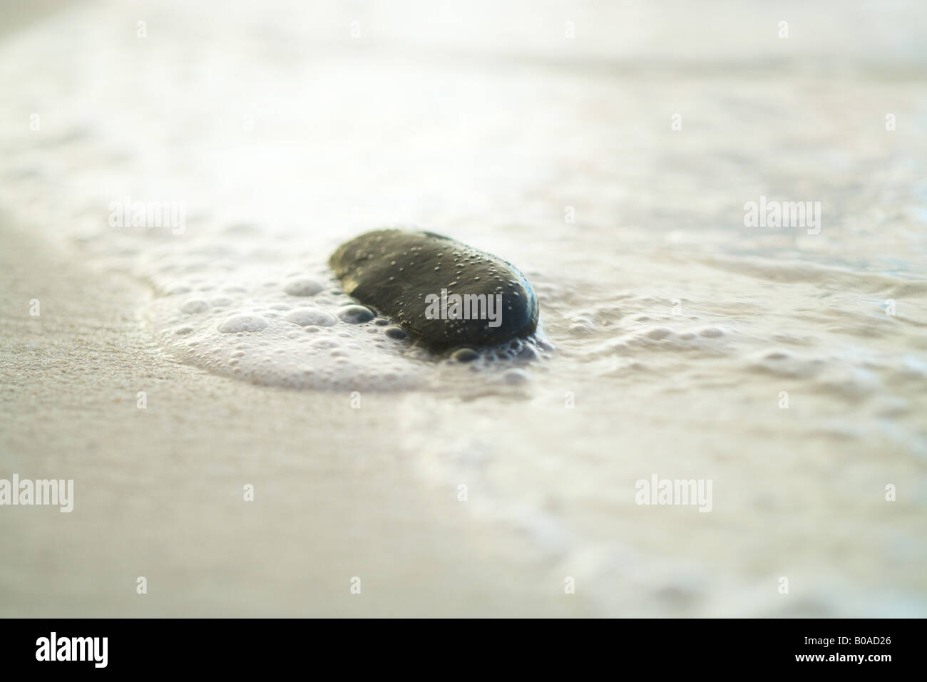Beach pebble and surf, close-up Stock Photo - Alamy