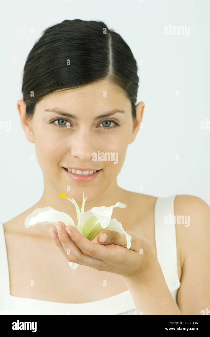 Woman holding lily, smiling at camera, portrait Stock Photo - Alamy