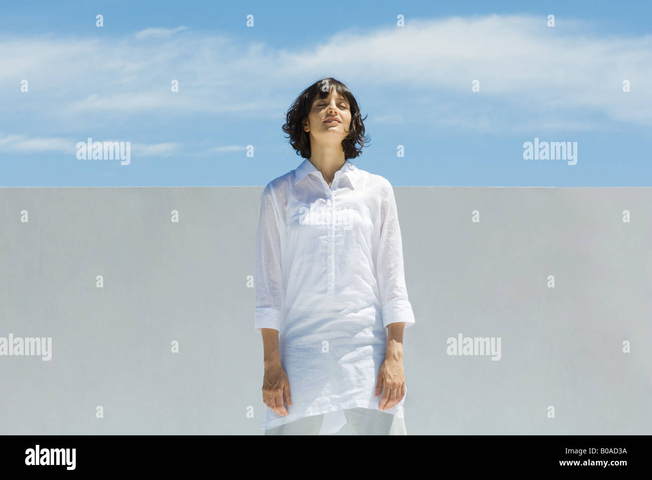 Woman standing outdoors with eyes closed, head back, smiling Stock ...