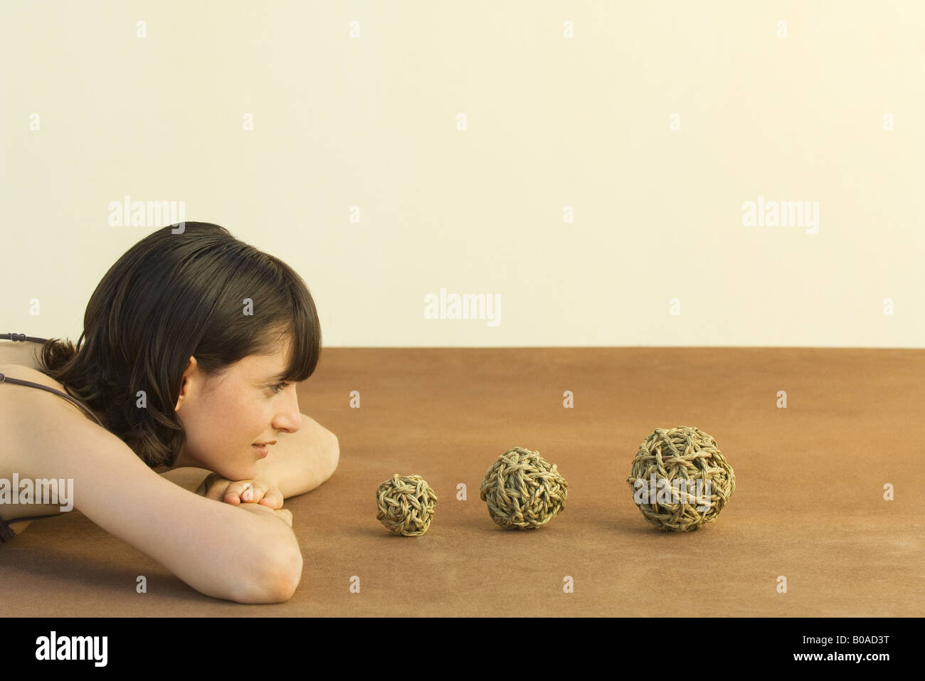 Woman resting head on arms, looking at balls of string, side view Stock ...