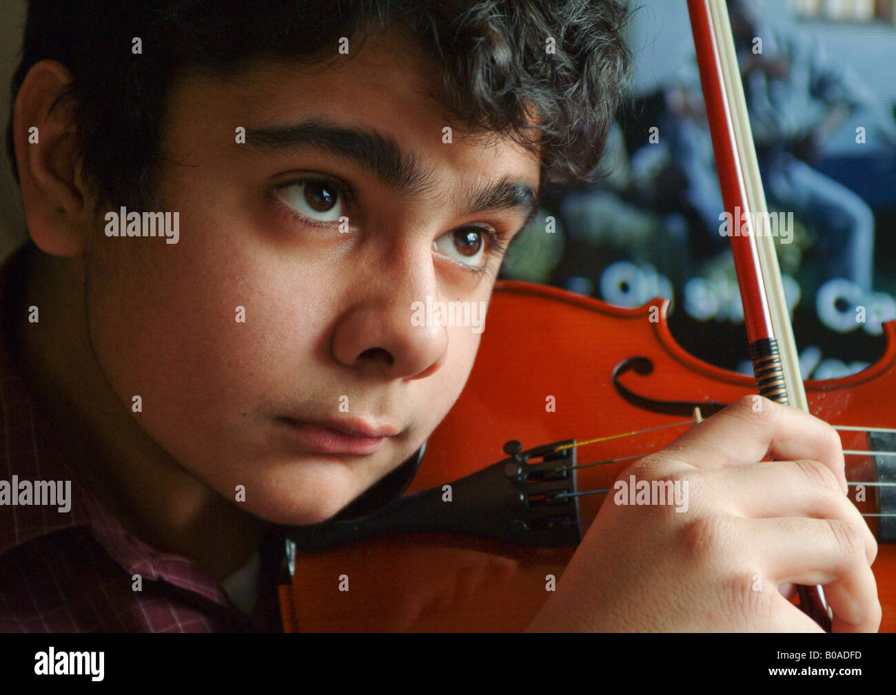 A young boy playing violin with serious dedication in his music to ...