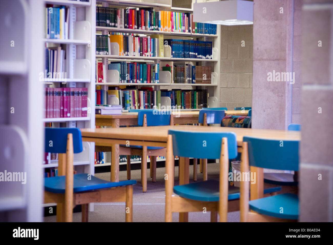 Bookshelves tables and chairs in a college library Stock Photo - Alamy
