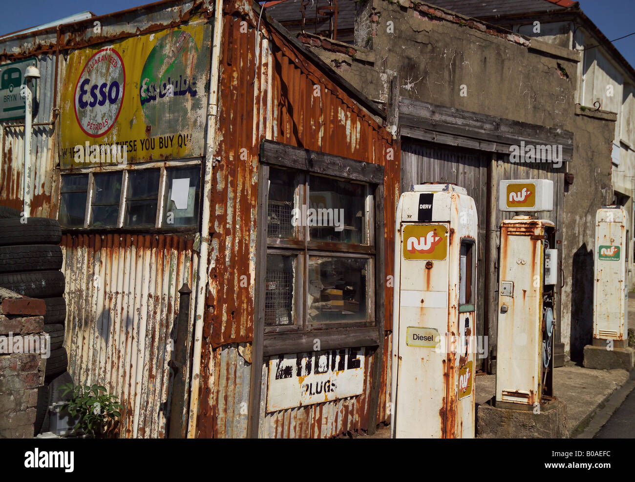 Derelict and very old petrol station showing rusty pumps and forecourt ...