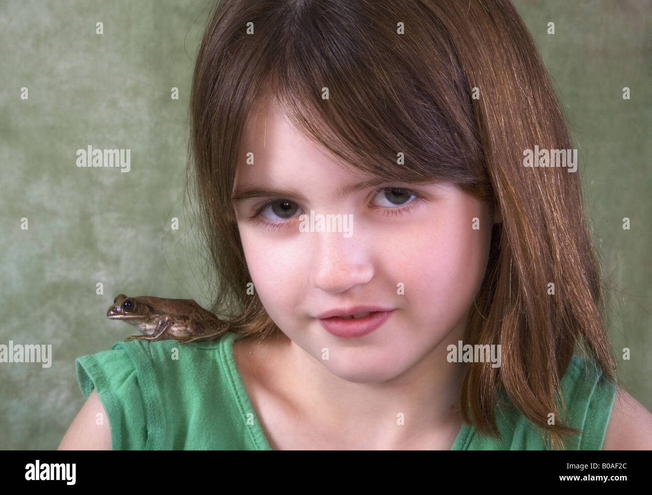 Young girl and her pet frog on green background Stock Photo - Alamy
