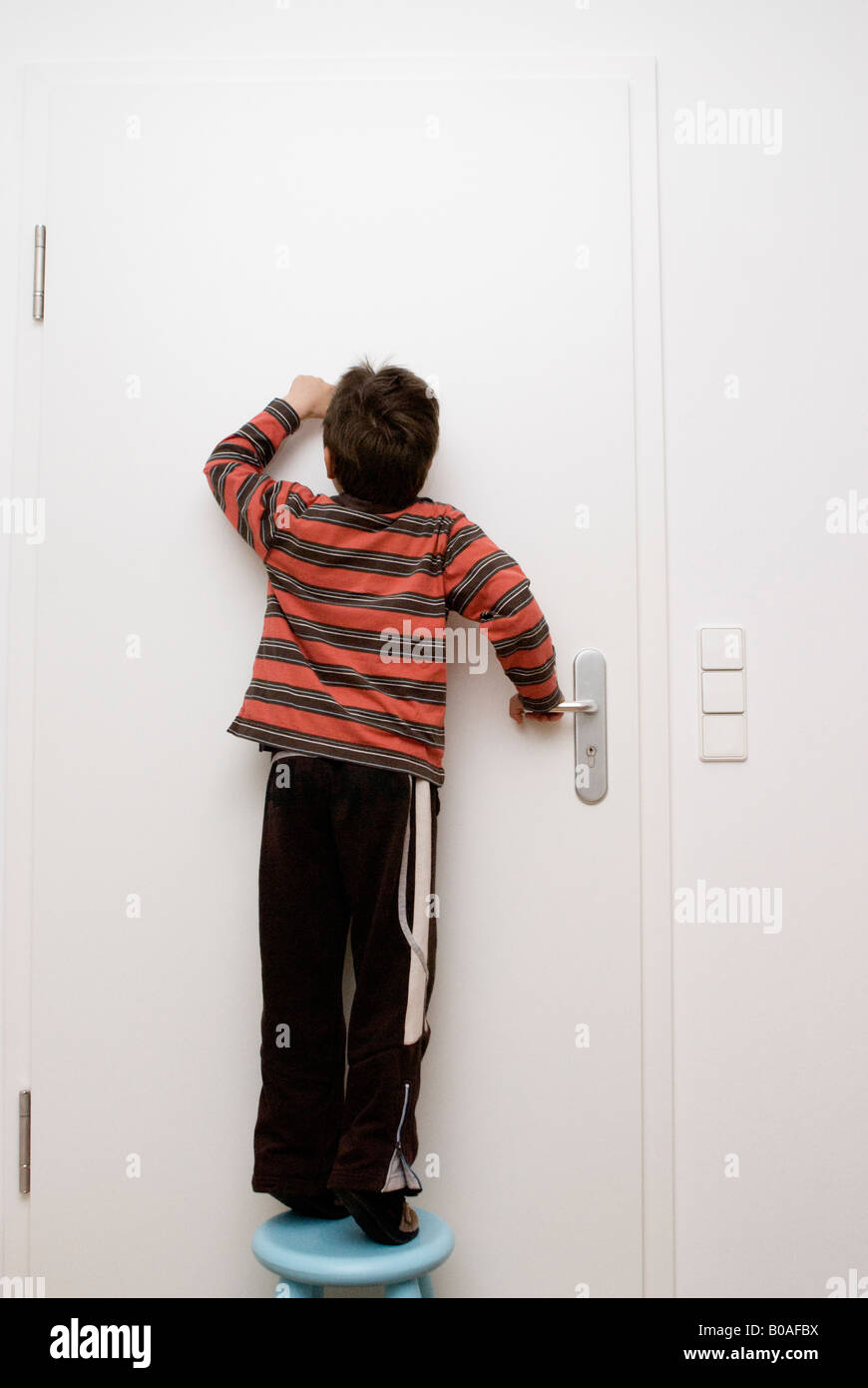 Child looking through the peephole Stock Photo - Alamy