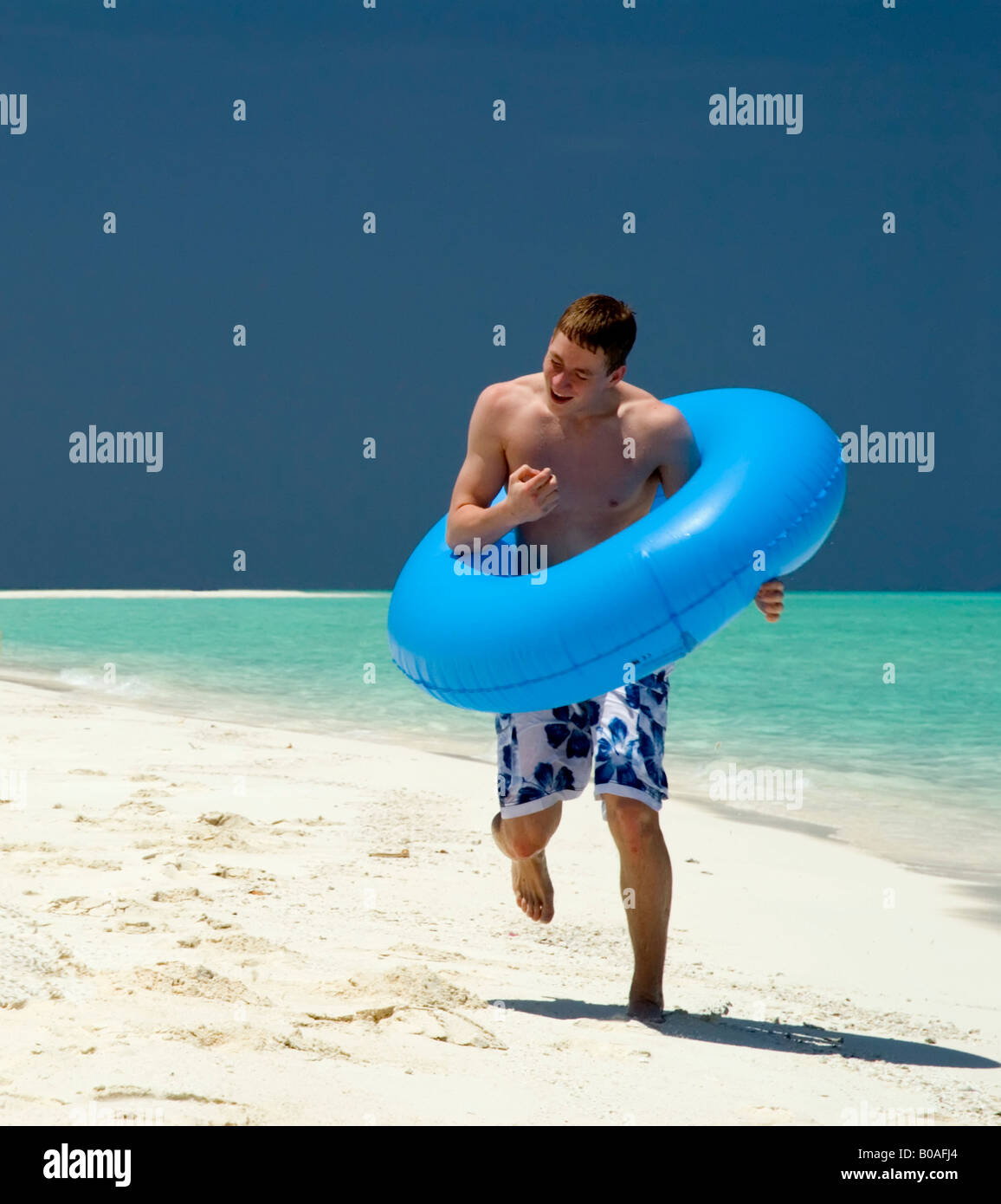 Teenage boy young man running on sandspit tropical sandy beach with ...