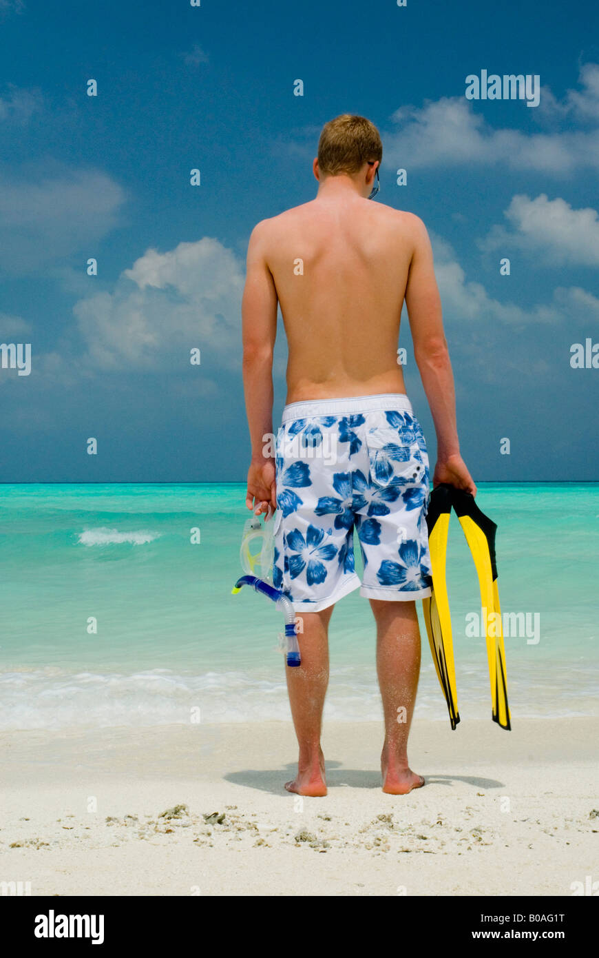 Young man teenager with snorkelling equipment Mares fins stands looking ...