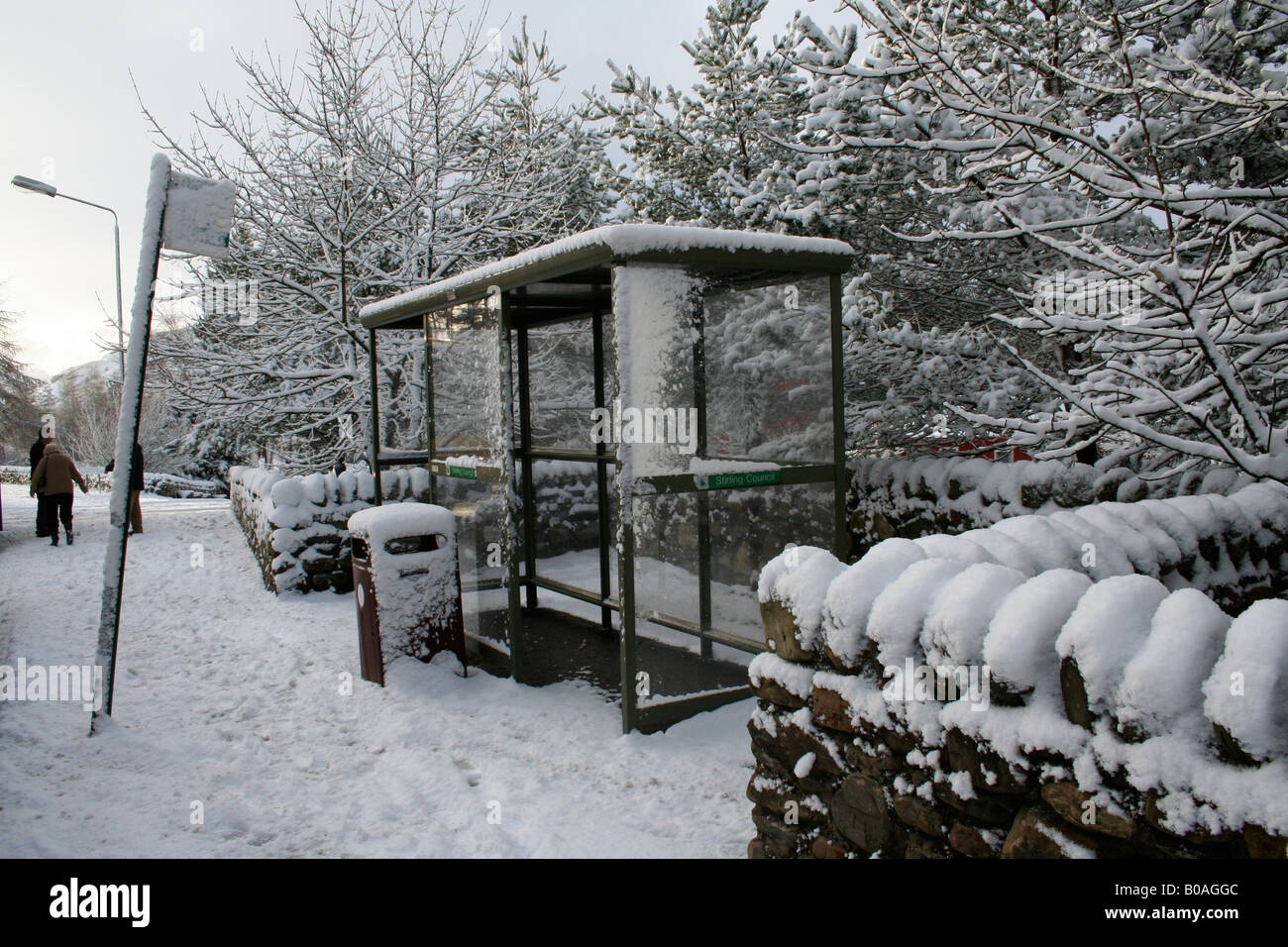 Bus shelter in the snow with passenger Stock Photo - Alamy