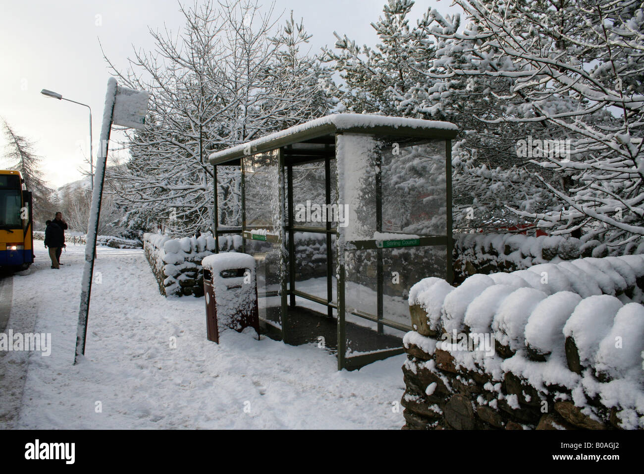 Coach stopping by a bus shelter in the snow Stock Photo - Alamy