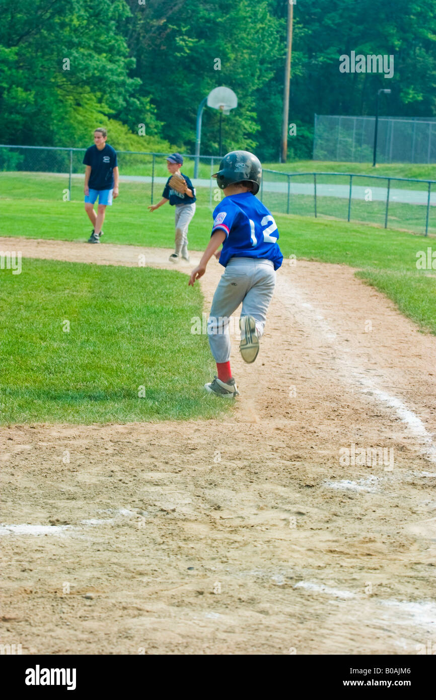 Young boy the batter running to first base during a Little League ...