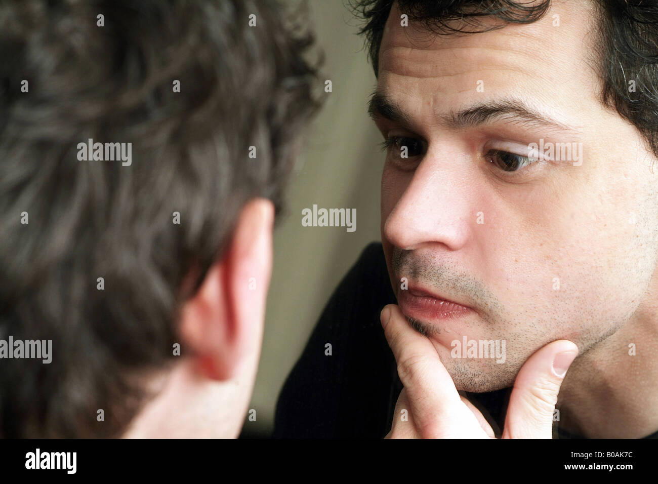 Man looking at himself in a mirror Stock Photo - Alamy