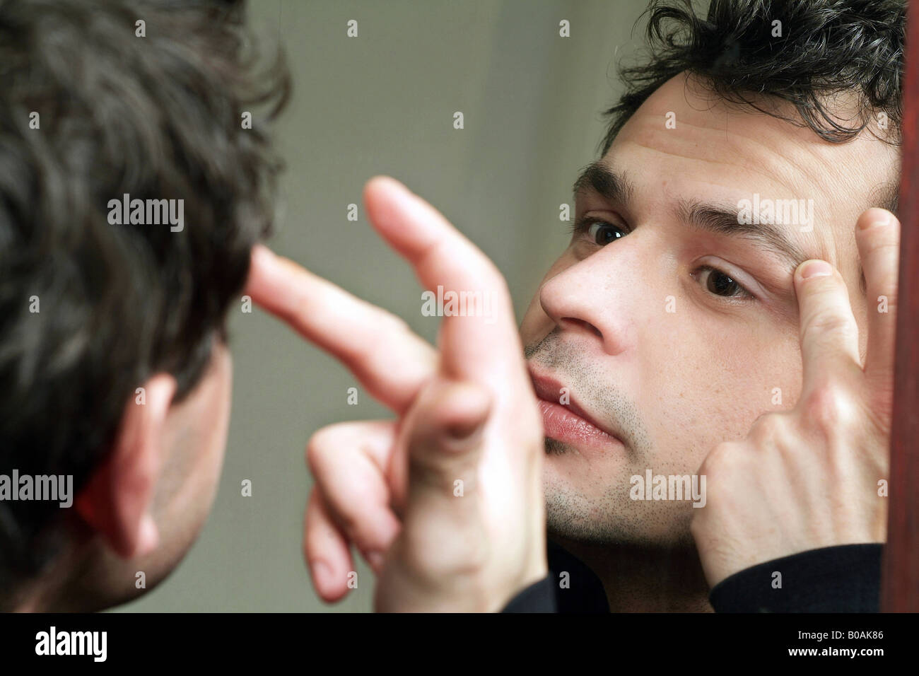 Man looking at himself in a mirror Stock Photo - Alamy