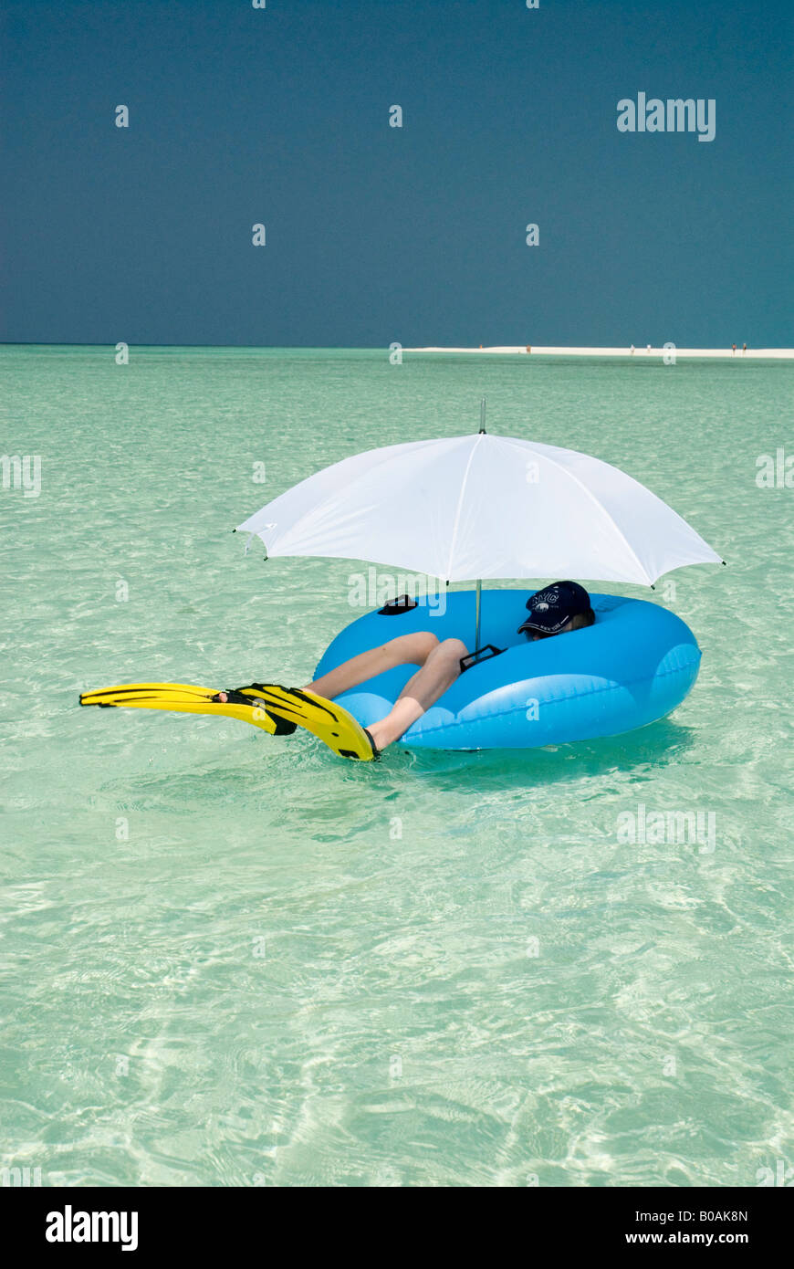 Person floating on rubber ring protected by white sunshade with Mares ...
