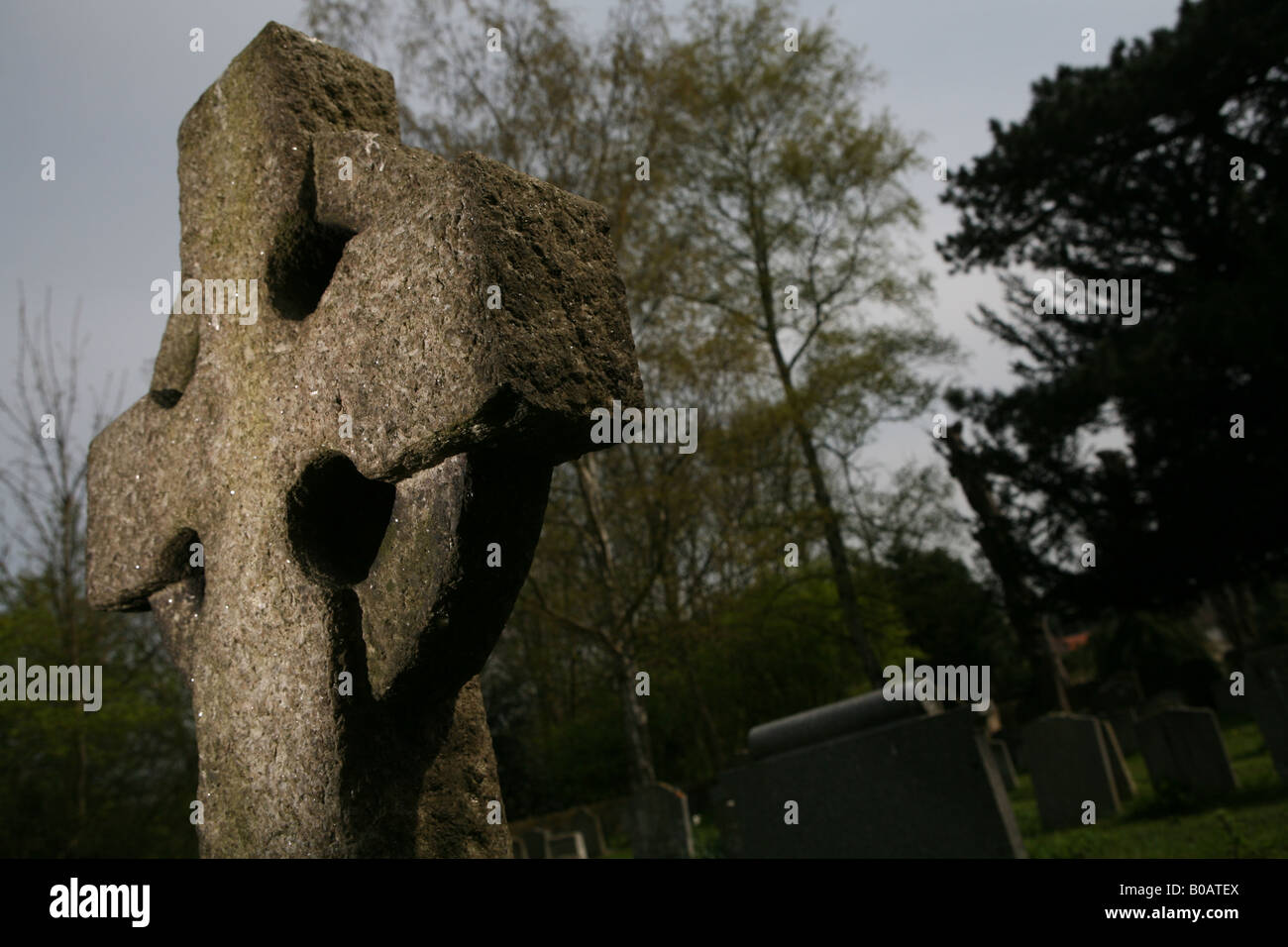 a sinister picture of a grave stone with a dark shadowy background ...