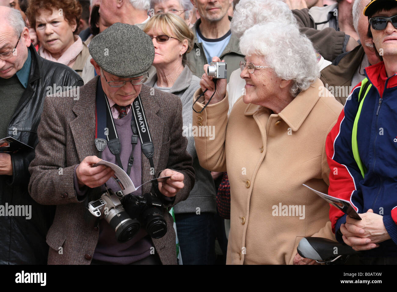 Elderly couple with their cameras taking photos in a crowd in the UK ...