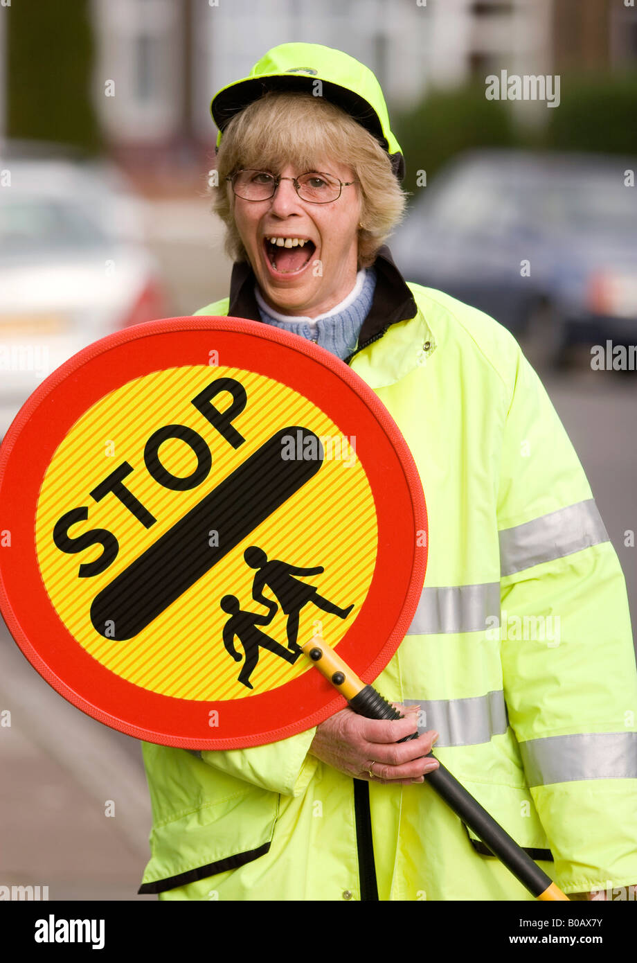 Lollypop lady, school traffic warden, with stop sign at school crossing ...