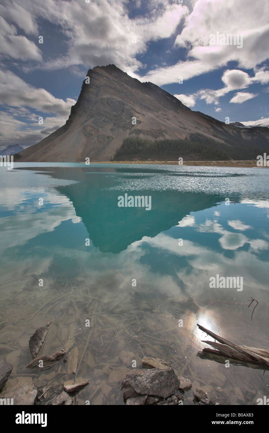 The huge rock of the triangular form is reflected in emerald waters of ...