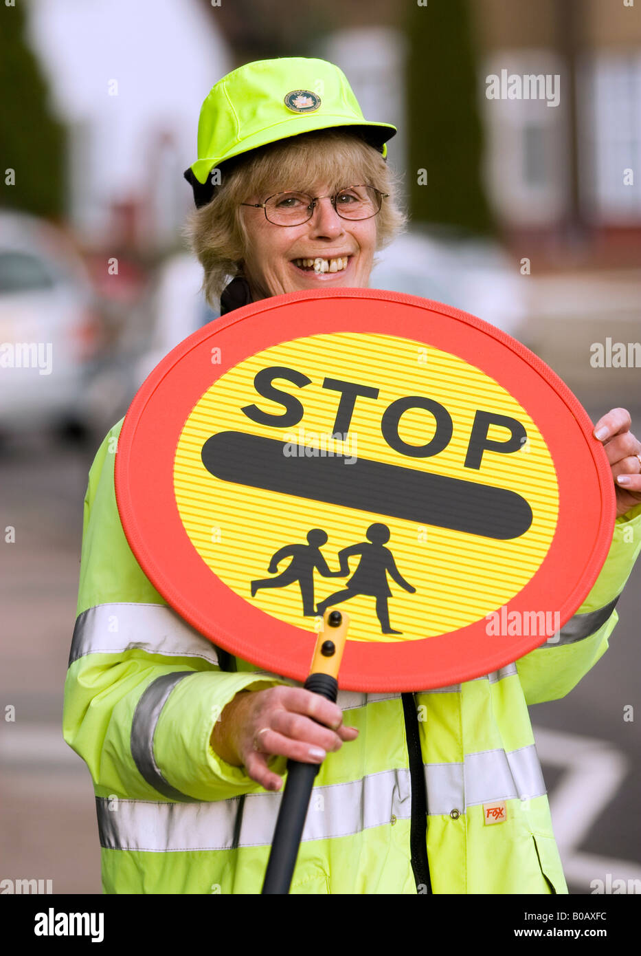 Lollypop lady, school traffic warden, with stop sign at school crossing ...