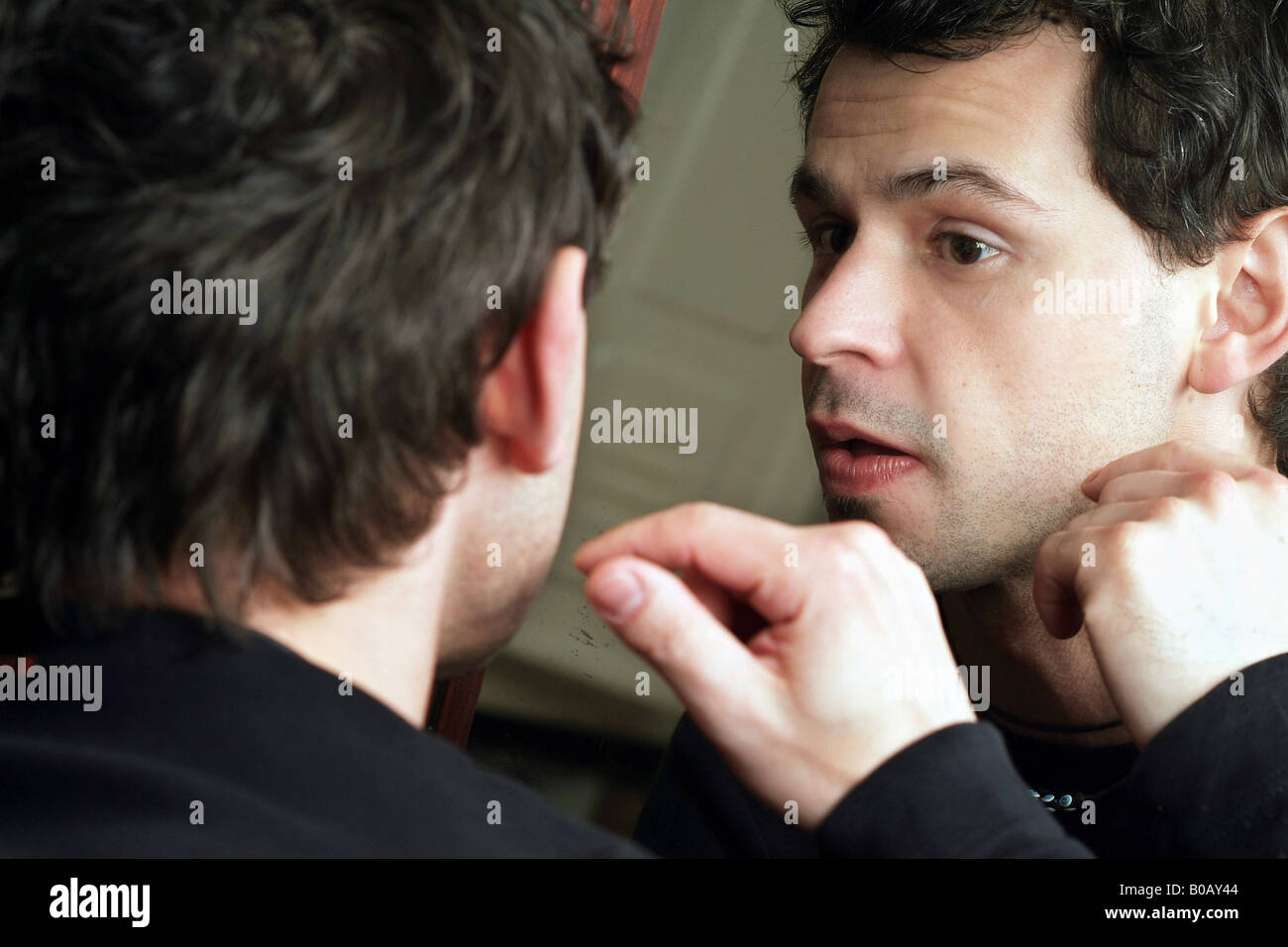 Man looking at himself in a mirror Stock Photo - Alamy