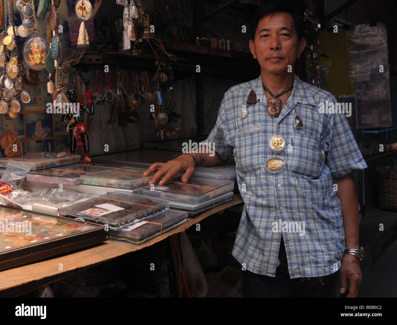 man with amulets around his neck posing , amulet market, bangkok ...