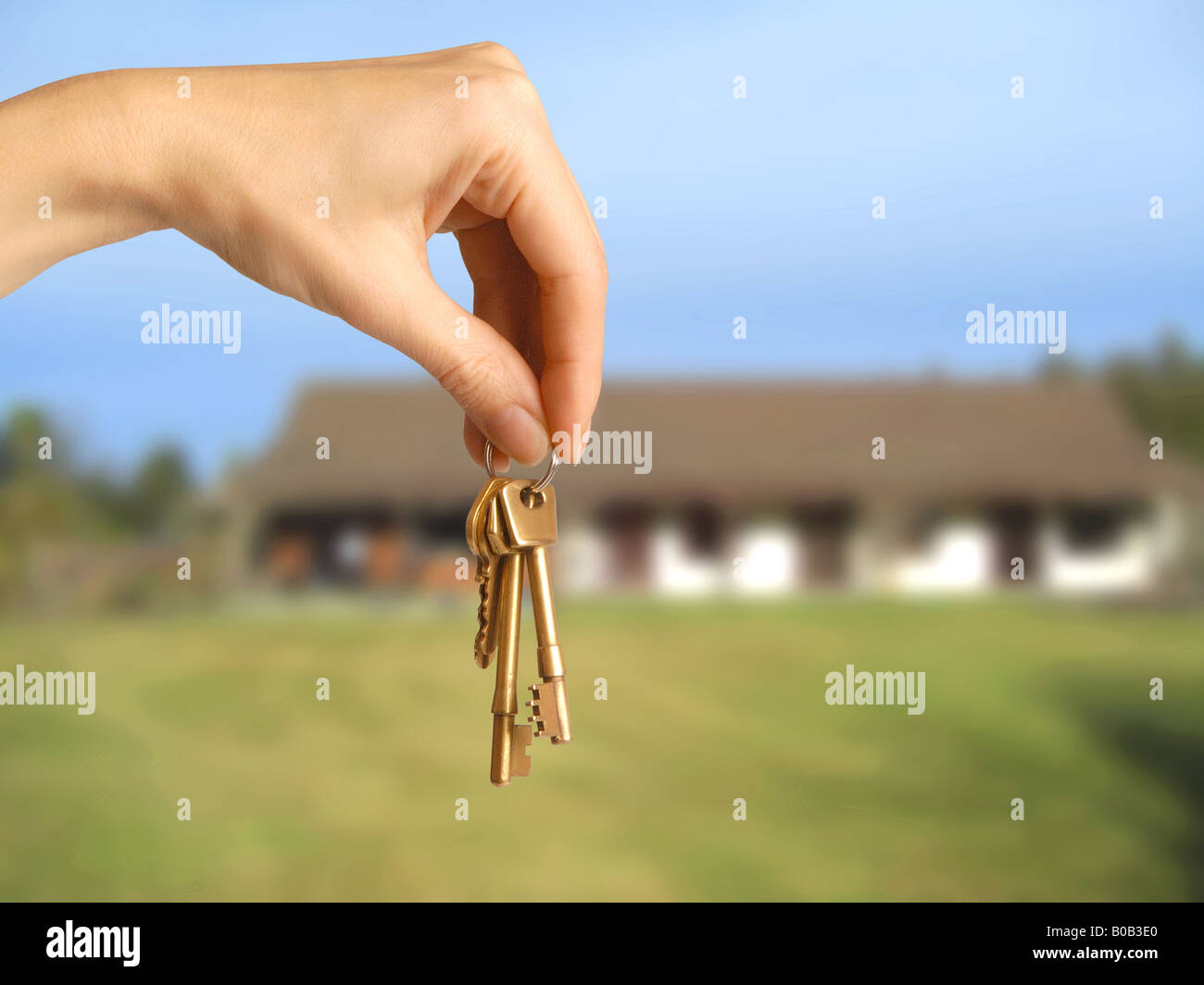 female hand holding house keys in front of building Stock Photo - Alamy