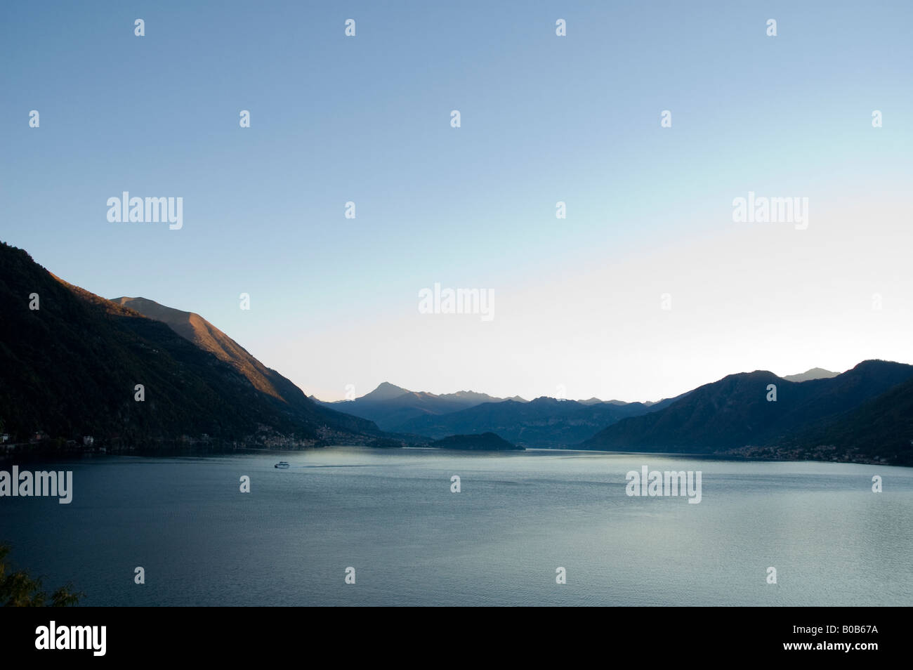 Dawn with a cloudless sky at Lake Como with the early morning commuter ...
