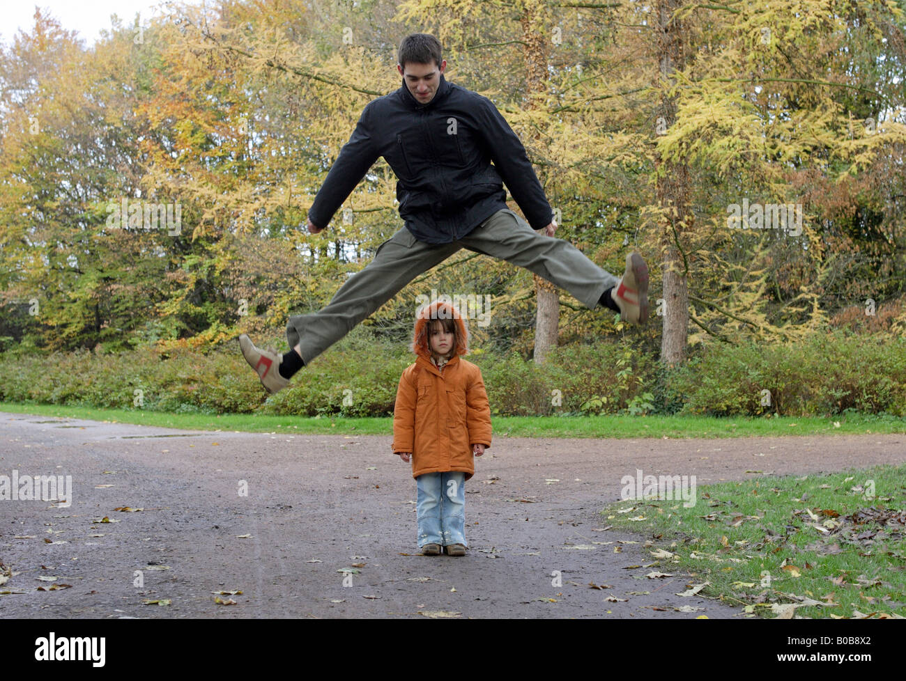 Man jumping over a kid in a park Stock Photo - Alamy