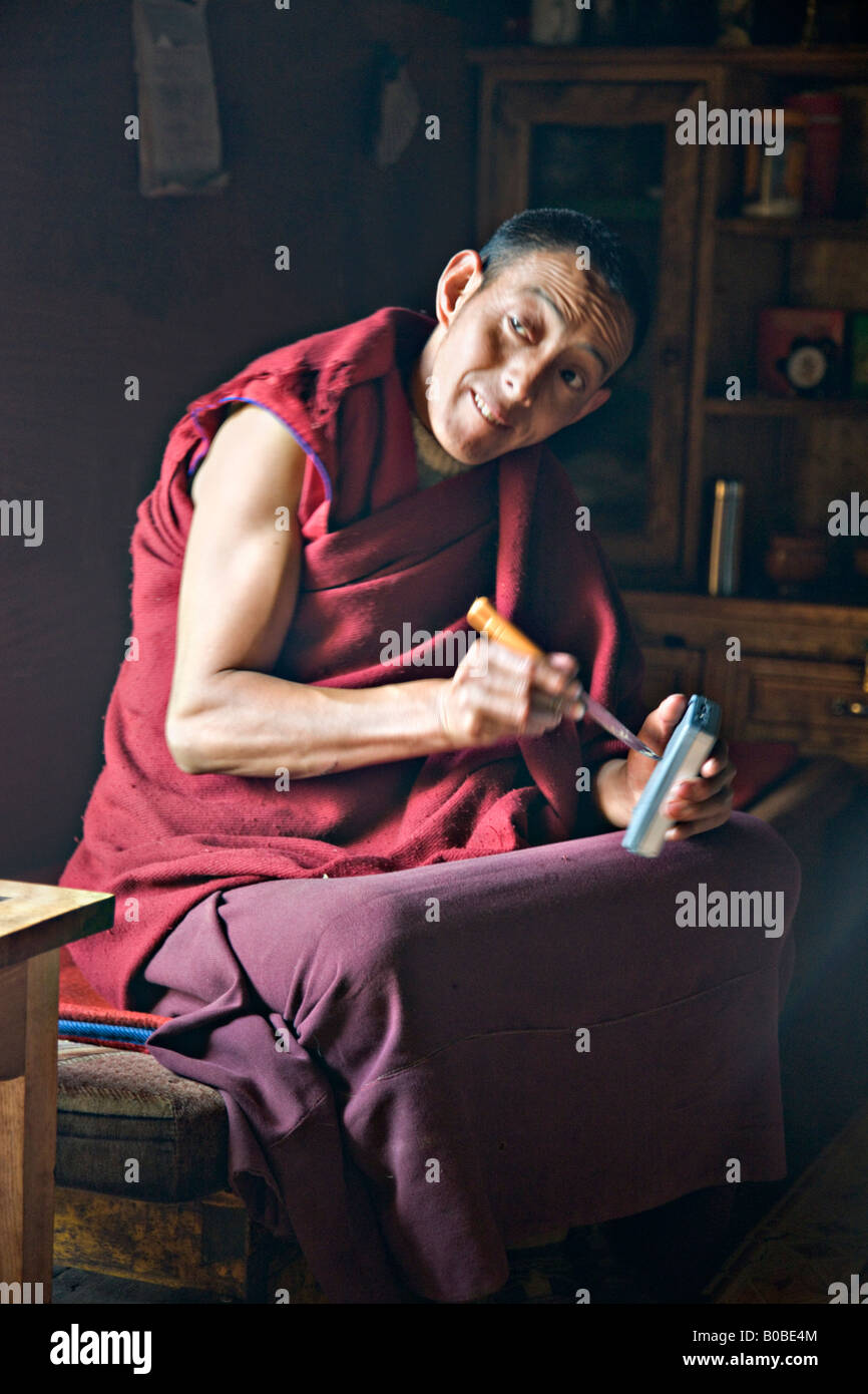 Buddhist monk repairing transistor radio with knife, Sungtseling ...