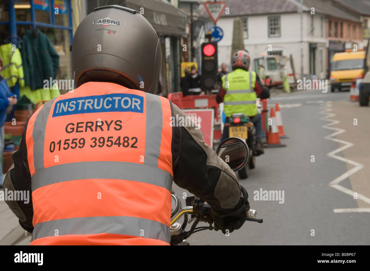 Motorcycle instructor giving lesson to a rider - following a learner ...