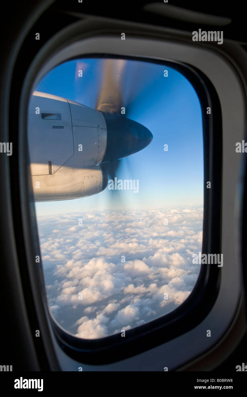 Airplane engine and propeller in flight viewed through the cabin window ...