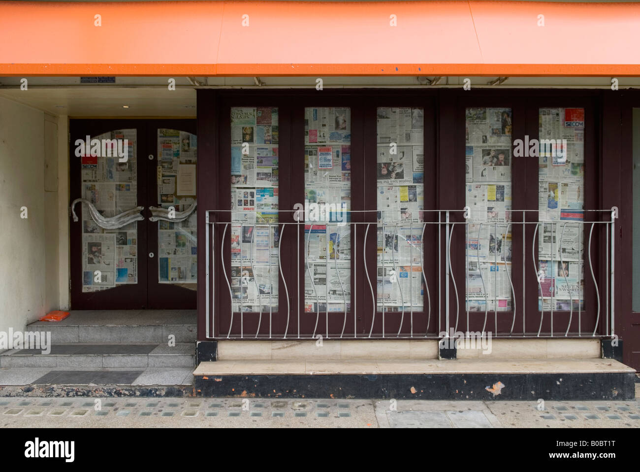 Closed restaurant with newspaper in the windows Stock Photo - Alamy
