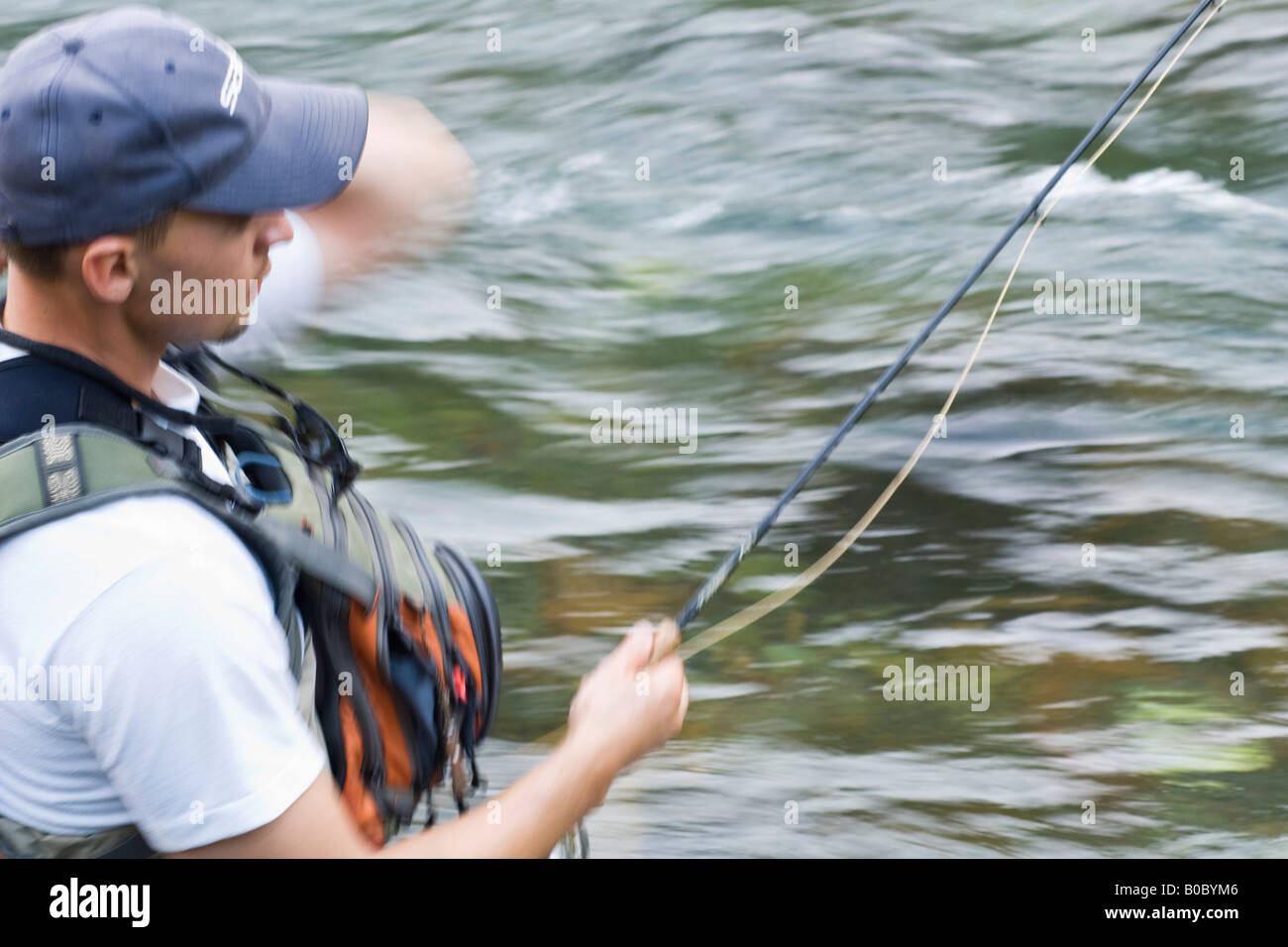 A man fly fishing with action blur Stock Photo - Alamy
