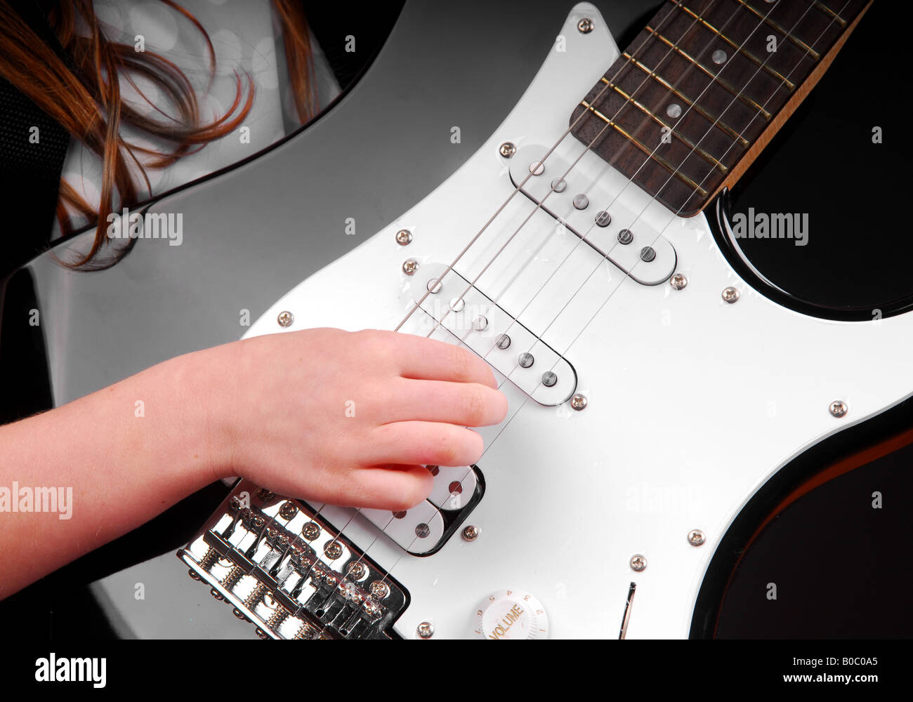 Girl playing electric guitar with hand on strings Stock Photo - Alamy