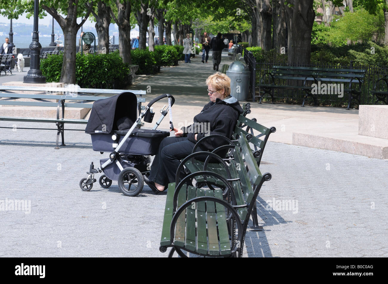 A nanny with an infant in a pram in a park in Lower Manhattan Stock ...