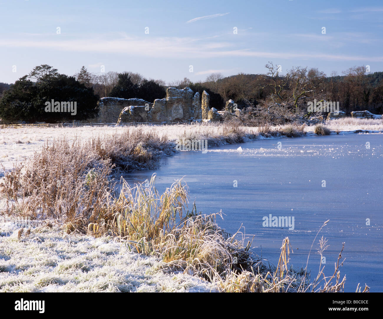 WAVERLEY ABBEY in the snow from across the frozen lake in winter ...