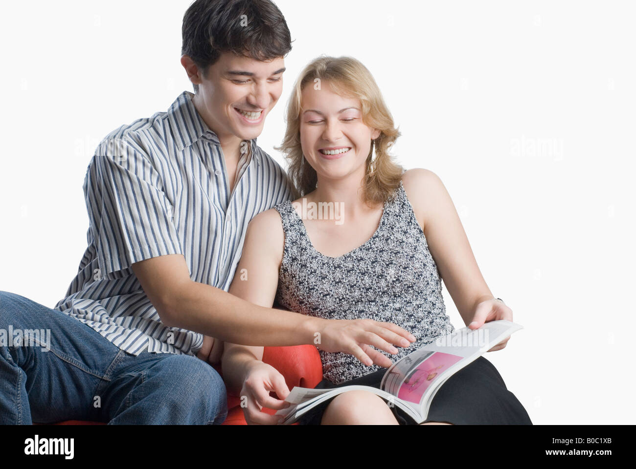 Two young women reading magazine sitting hi-res stock photography and ...