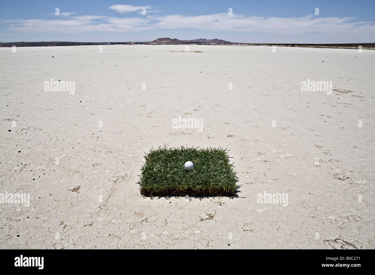Golf ball on a patch of grass in the desert Stock Photo - Alamy