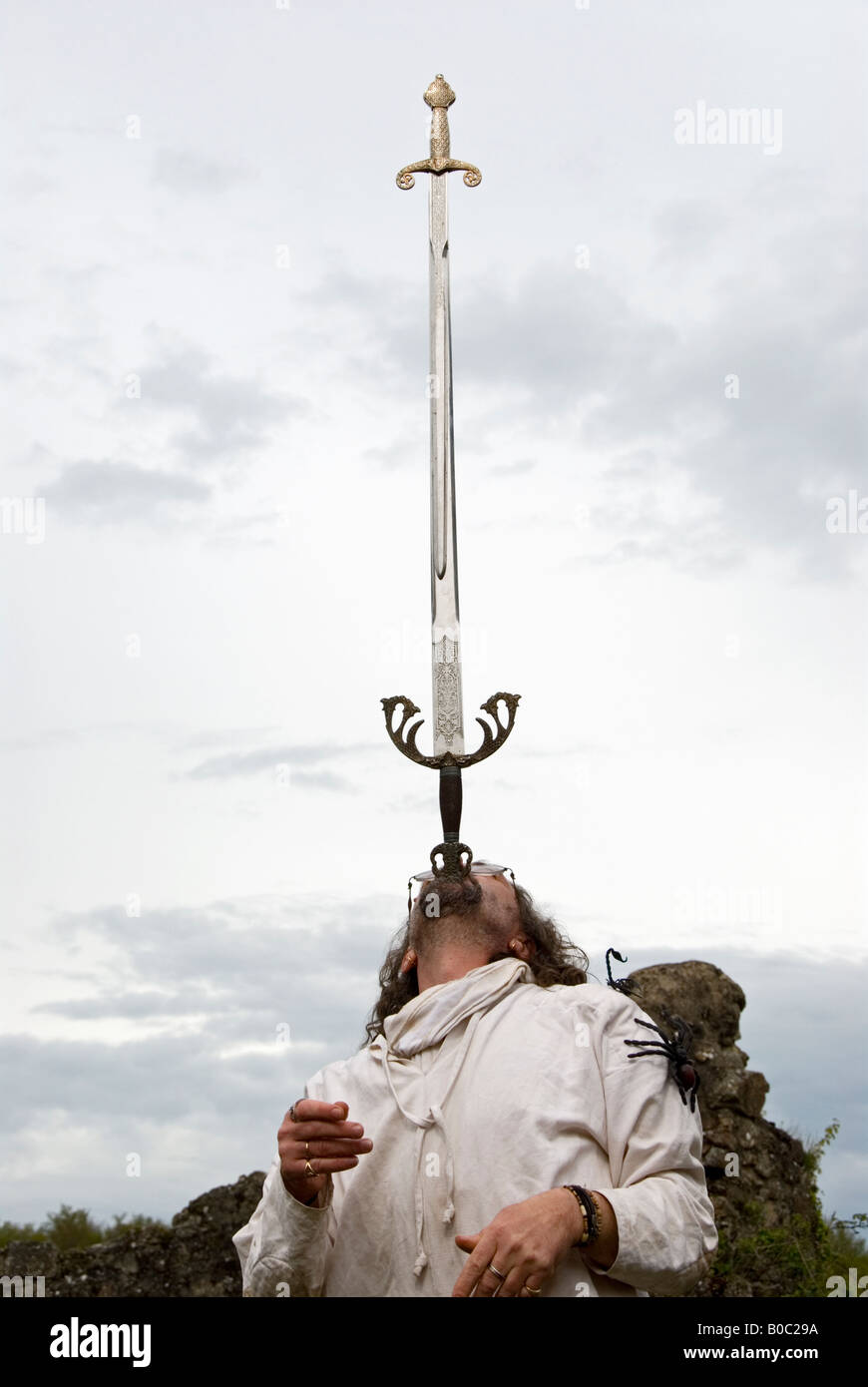 Stock photo of an actor at a medival pageant balancing swords on his ...