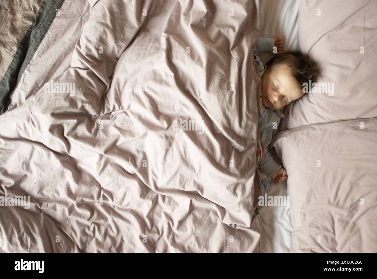 Baby sleeps on an empty double bed Stock Photo - Alamy