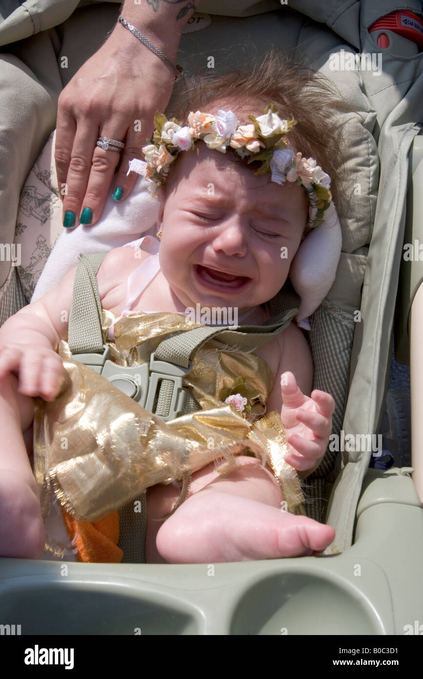 Crying infant wearing a wreath at the Mermaid Parade at Coney Island ...