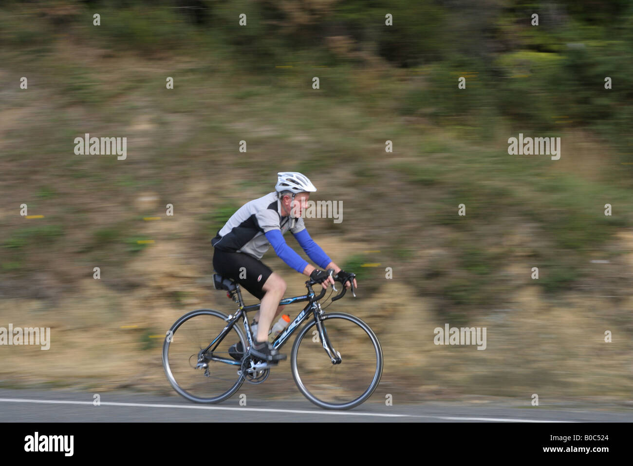 Man cycling along a rural road Stock Photo - Alamy