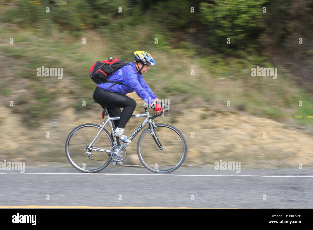 Man cycling along a rural road Stock Photo - Alamy