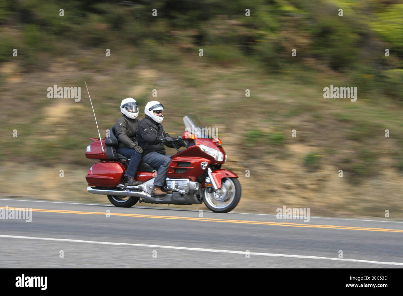 Motorcyclist with pillion passenger traveling down a country road Stock ...