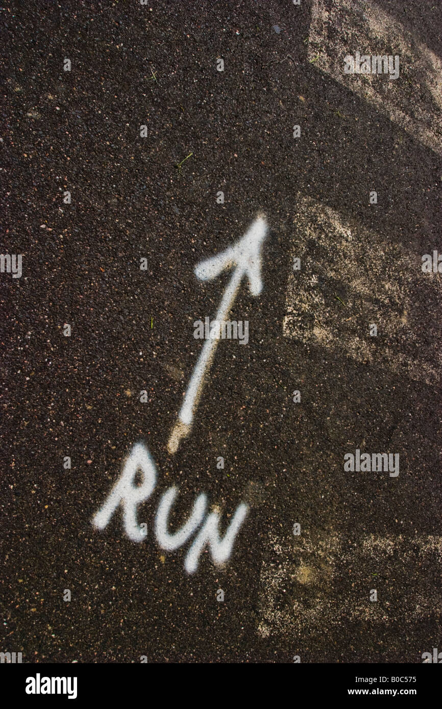 The word RUN and an arrow written on the street Stock Photo - Alamy