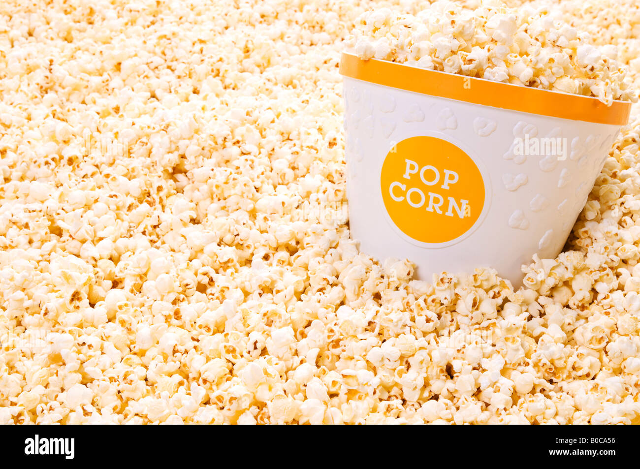 Popcorn tub on a background of popcorn Stock Photo - Alamy