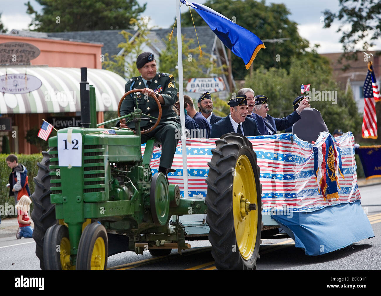 Image of an Army Officer driving a John Deere tractor pulling a cart ...