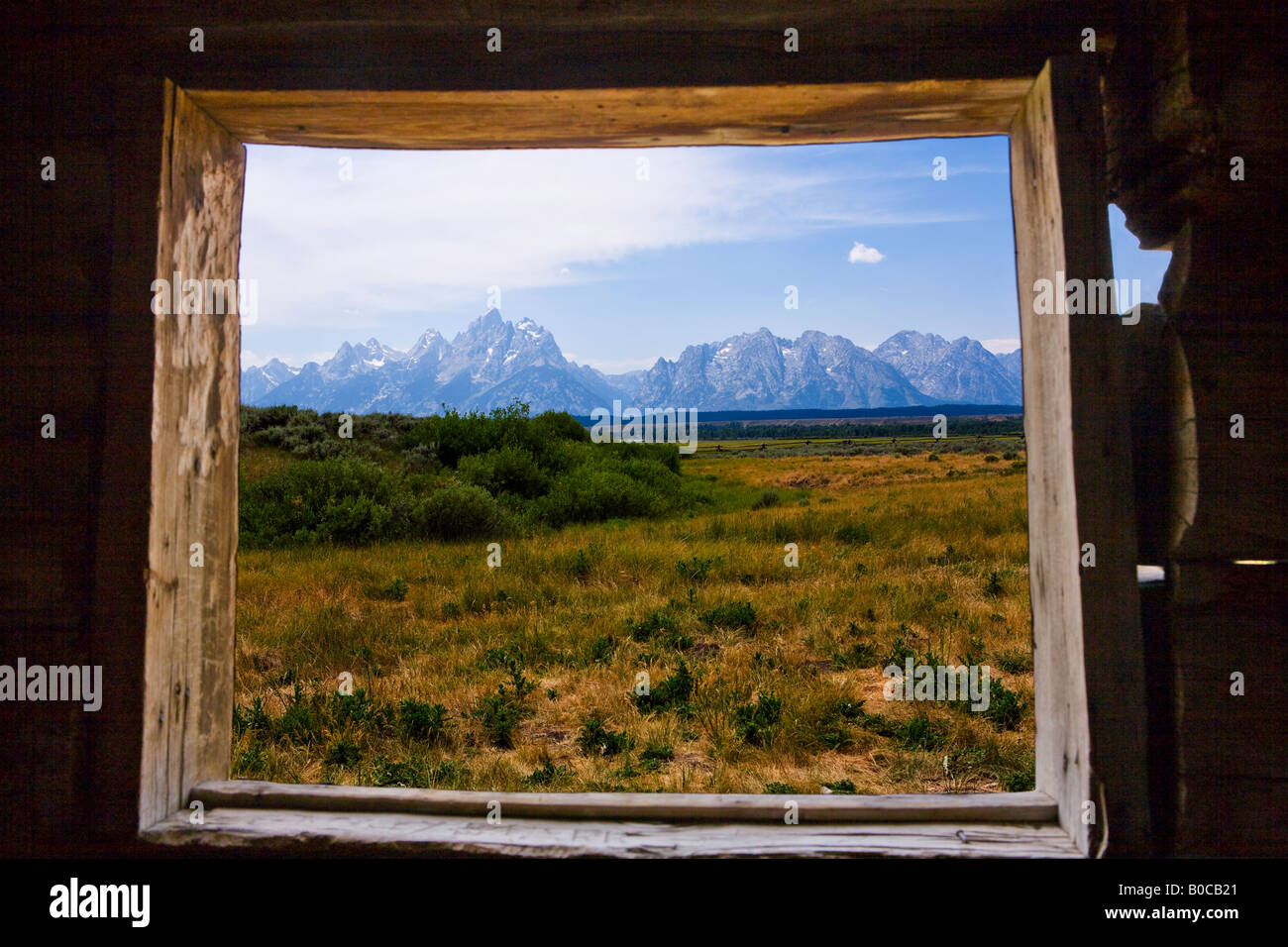 Image of the Grand Teton Mountains looking through a window of a log ...
