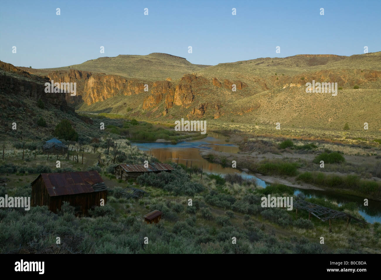 The Owyhee River winds through ryolite canyons passing an old ranch at ...
