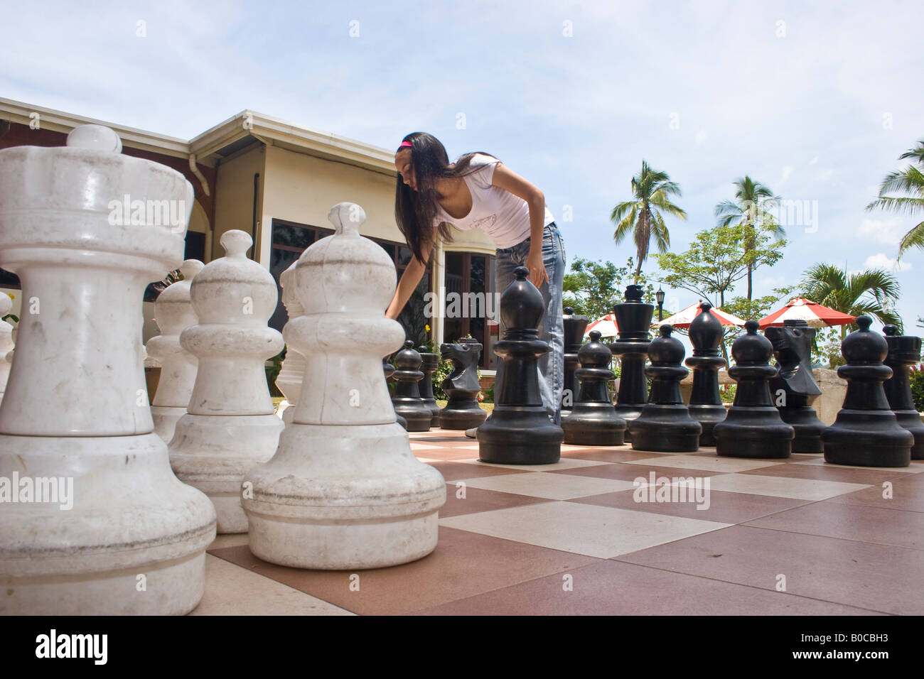 Teenage girl playing giant chess Stock Photo - Alamy